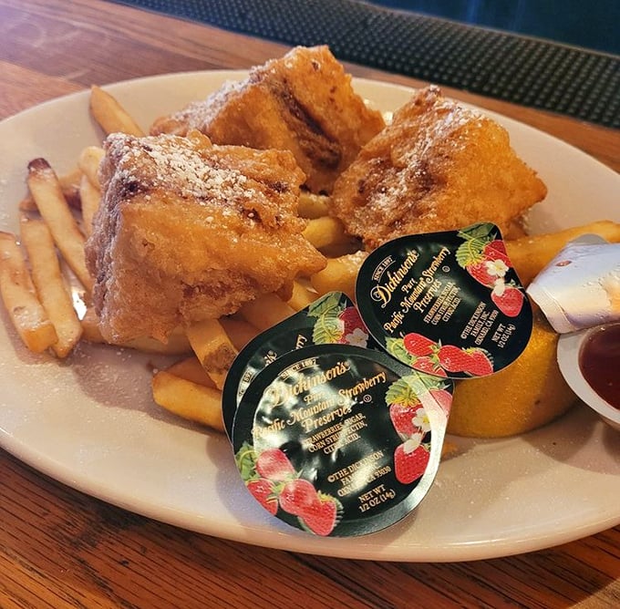 The legendary Monte Cristo arrives like a golden treasure chest, dusted with powdered sugar and hiding savory secrets within its crispy exterior.