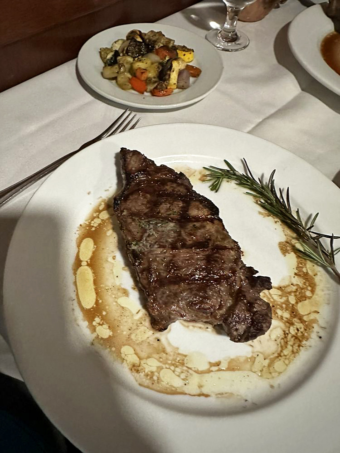 This New York Strip isn't just a steak; it's a masterpiece of marbling and char, resting in a pool of sauce that deserves its own Instagram account.