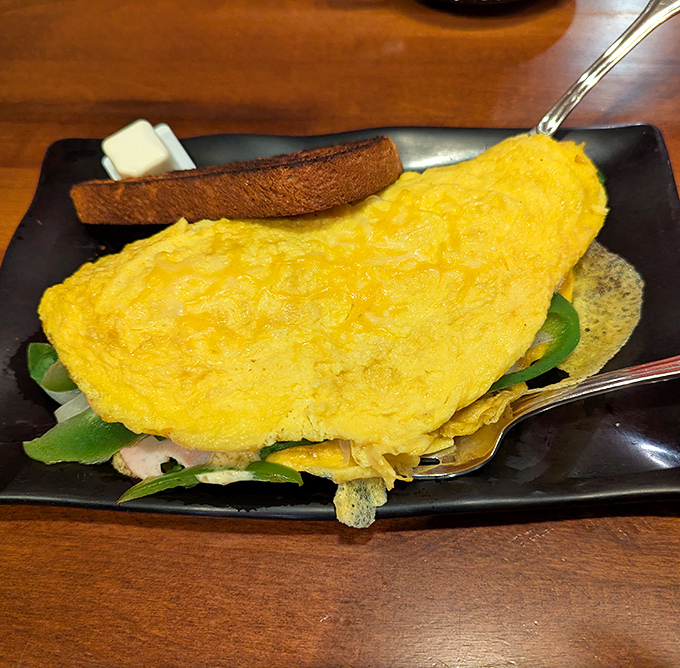 This isn't just an omelet; it's a fluffy yellow canvas of breakfast possibilities, perfectly executed and ready for its close-up.