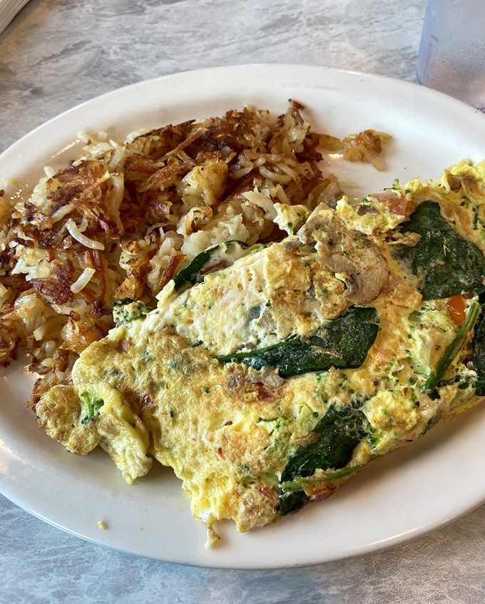 A spinach omelet that would make Popeye weep tears of joy, paired with hash browns crisped to golden perfection.
