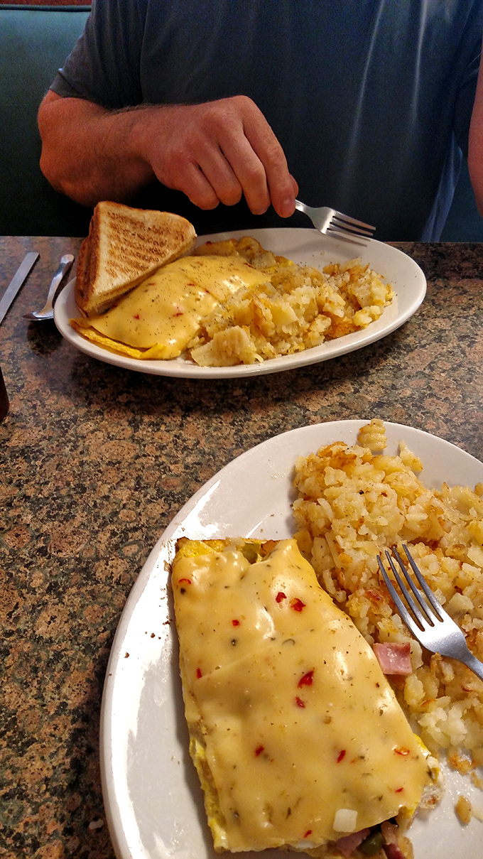 When your omelet comes draped in cheese that practically winks at you, paired with home fries that crackle with each bite, diet plans surrender immediately.