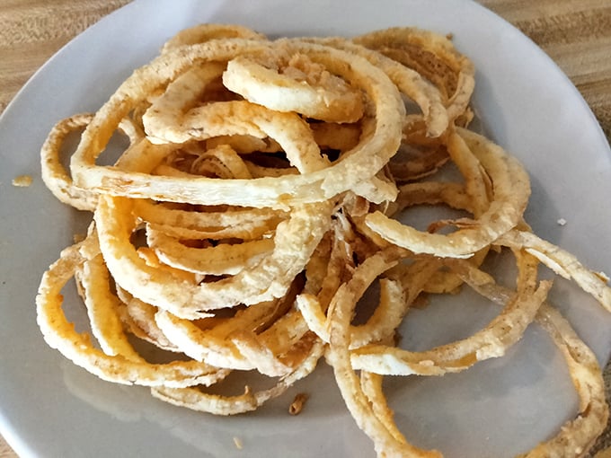 These aren't just onion rings; they're crispy golden halos that make you question why you'd ever waste stomach space on anything else.