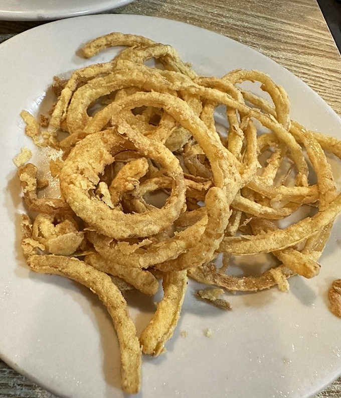 Perfectly fried onion rings that crunch like nature's edible jewelry. The supporting act that deserves its own standing ovation.