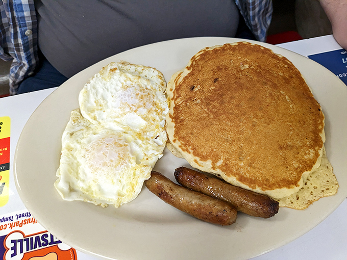 This pancake could moonlight as a frisbee, but you'd never throw it &ndash; not when it's flanked by perfectly cooked eggs and sausage links. 