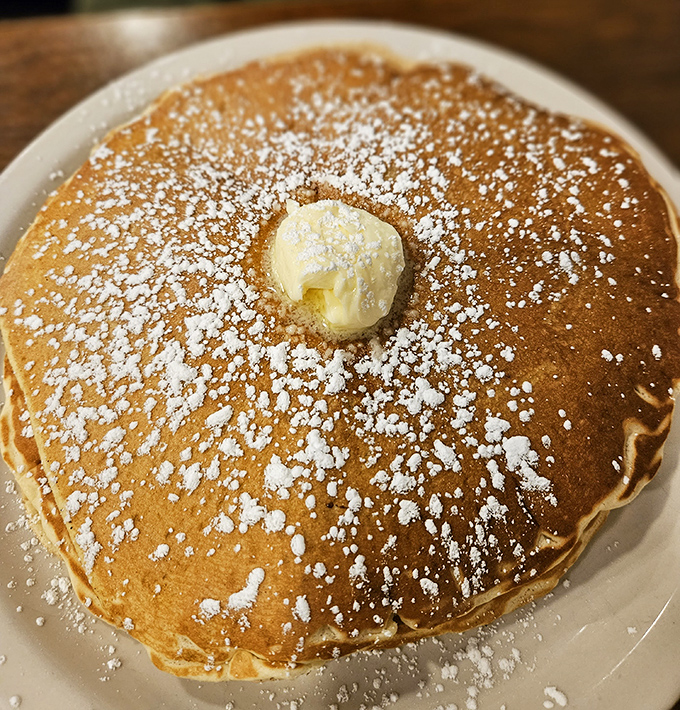This pancake isn't just breakfast&mdash;it's a fluffy canvas of possibility, dusted with powdered sugar and crowned with a melting pat of butter.