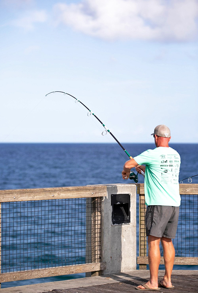 Patience personified: The age-old dance between angler and ocean unfolds on Florida's longest fishing pier, where hope springs eternal with every cast.