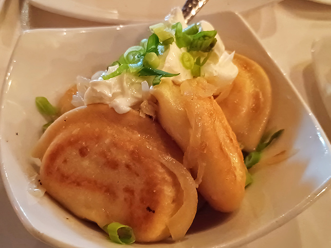 These golden pierogies arrive like little pillows of joy, topped with green onions and a dollop of what can only be described as happiness.
