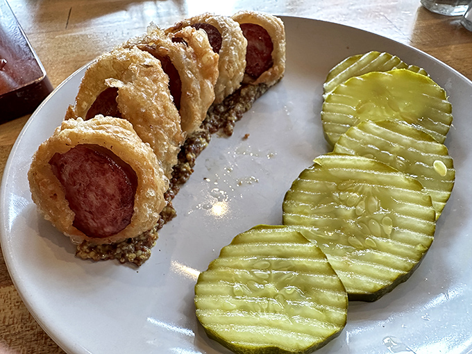 Pigs in blankets reimagined with gourmet flair, these crispy-wrapped sausages with house-made mustard prove childhood favorites can grow up without losing their soul.