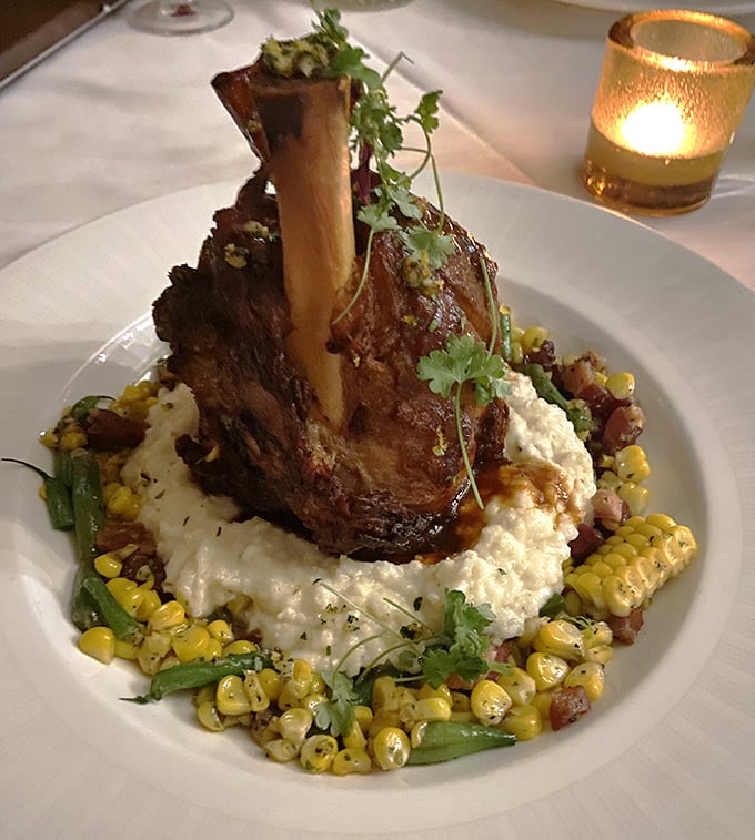 This lamb shank doesn't just fall off the bone &ndash; it practically leaps onto a cloud of creamy grits surrounded by a summer cornucopia.
