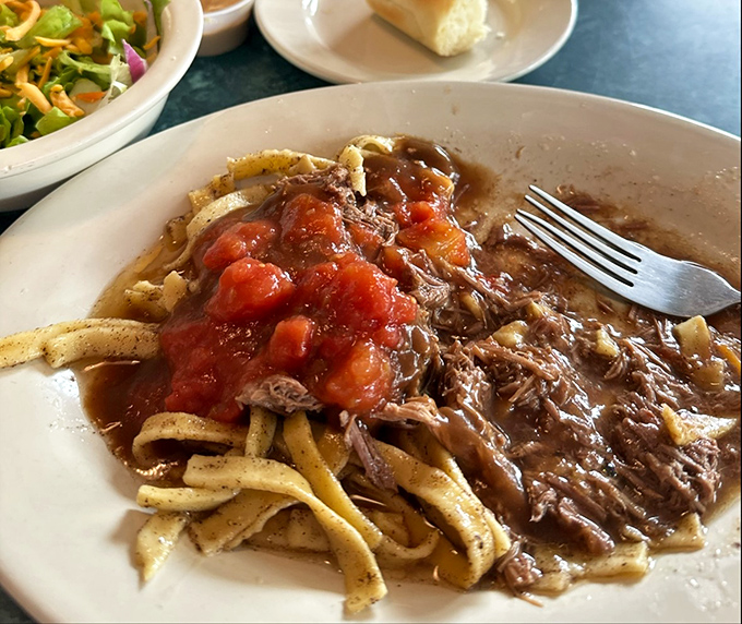 Pot roast over noodles with a side of stewed tomatoes&mdash;the kind of plate that makes you want to hug the chef and adopt their entire family.