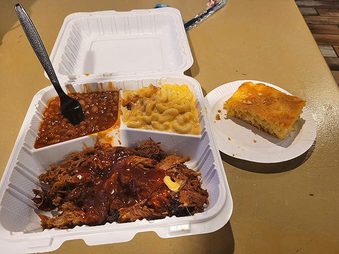 The holy trinity of barbecue bliss: pulled pork swimming in sauce, mac and cheese that's actually worth the calories, and cornbread that grandma would approve.