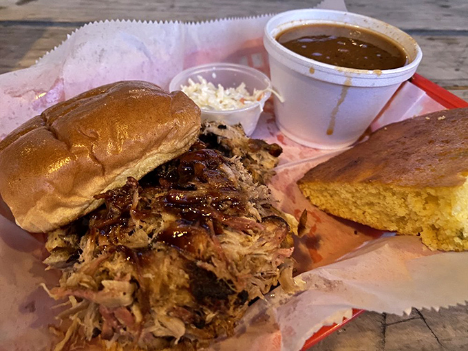 The pulled pork sandwich sits on its honey bun throne, surrounded by loyal subjects of cornbread and slaw&mdash;a royal feast for commoner prices.