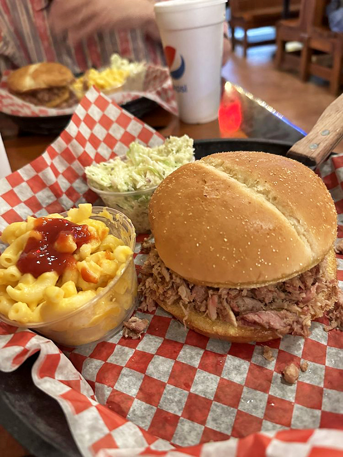 A pulled pork sandwich that requires strategic eating and zero shame. The mac and cheese isn't a side&mdash;it's an essential supporting character.