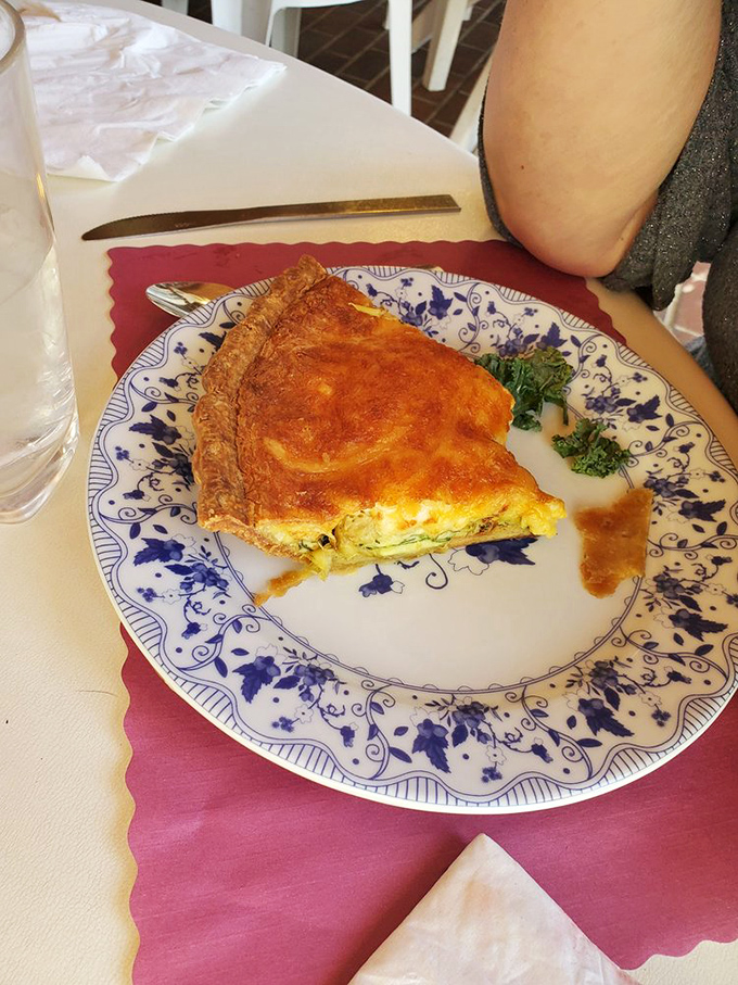 This quiche arrives with a golden crust that shatters just right, served on china that could tell stories from Sunday dinners past.