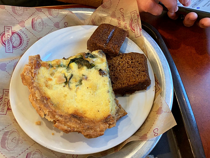 Breakfast of champions: a slice of quiche with a golden crust that shatters just right, paired with what appears to be homemade bread.