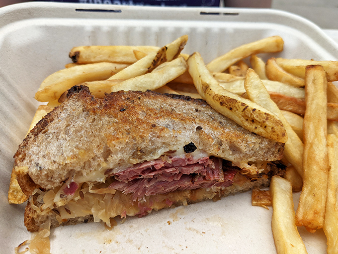 The Reuben sandwich, perfectly grilled with sauerkraut spilling out the sides, proves that sometimes the messiest foods are life's greatest pleasures.