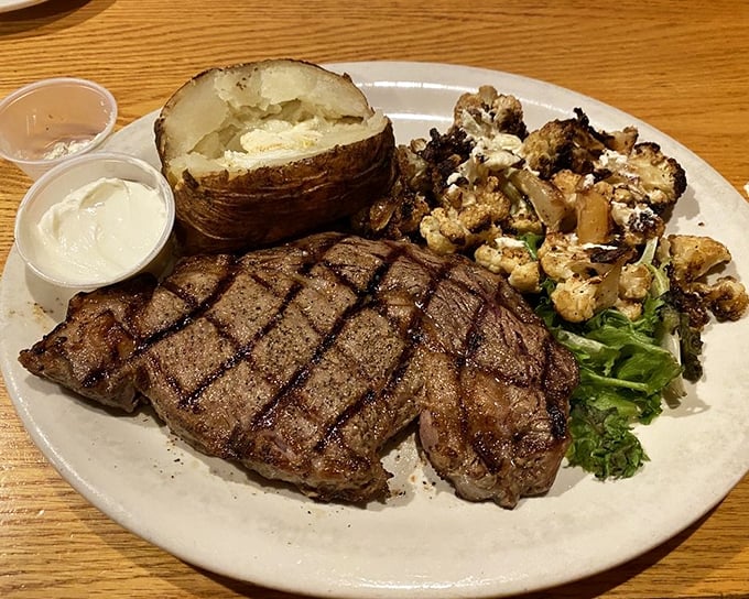This perfectly cross-hatched ribeye isn't just a steak &ndash; it's a carnivore's geometry lesson that pairs beautifully with that loaded baked potato.