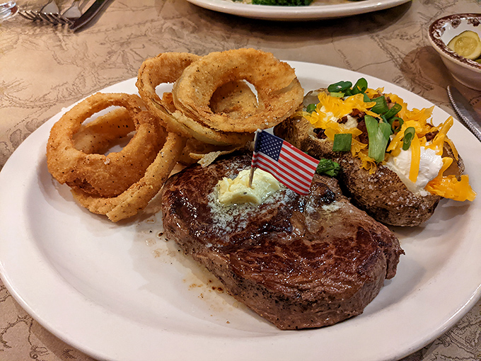 This isn't just a steak&mdash;it's a celebration on a plate, complete with those golden onion rings standing at attention like delicious sentries.