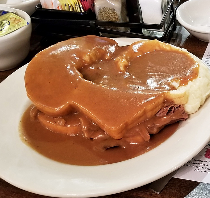 Not so much a sandwich as an architectural marvel of gravy. When your food needs its own watershed management plan, you know it's good.