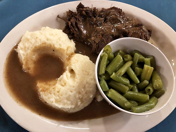 Roast beef so tender it surrenders immediately, paired with mashed potatoes sporting that perfect gravy divot—the dinner equivalent of a warm hug.