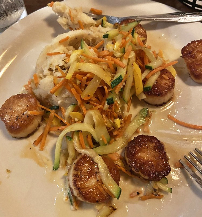 Perfectly seared scallops nestled alongside julienned vegetables and creamy mashed potatoes&mdash;seafood that tastes like it should cost twice as much.