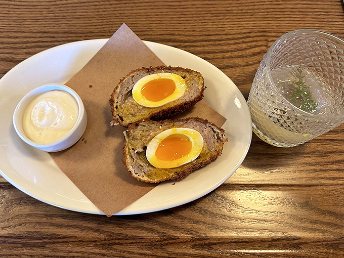 These Scotch eggs arrive like little golden presents, each bite revealing perfectly cooked yolk that's pure breakfast poetry.