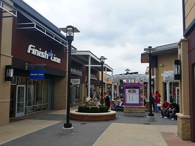 Finish Line and friends line this bustling corridor where shoppers strategize their next move like generals planning retail conquests.