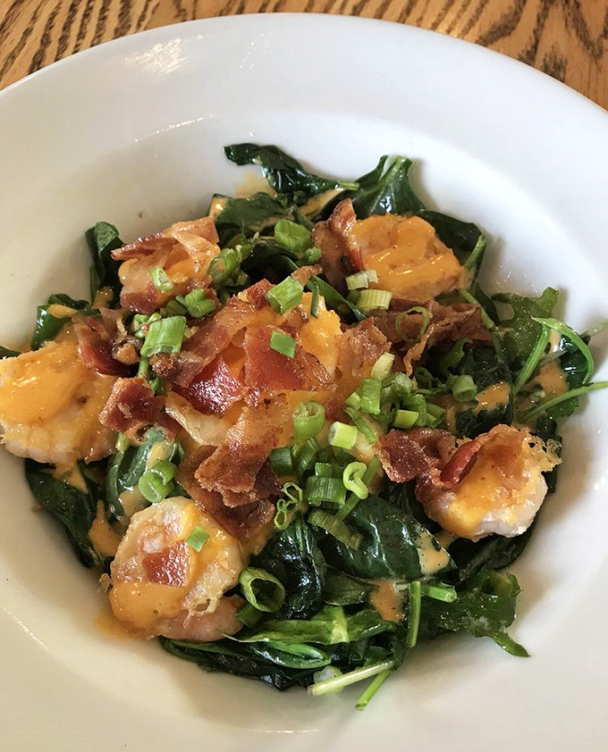 Not your grandmother's greens! Plump shrimp nestled on a bed of spinach with crispy bacon bits&mdash;proof that healthy and indulgent can coexist beautifully.