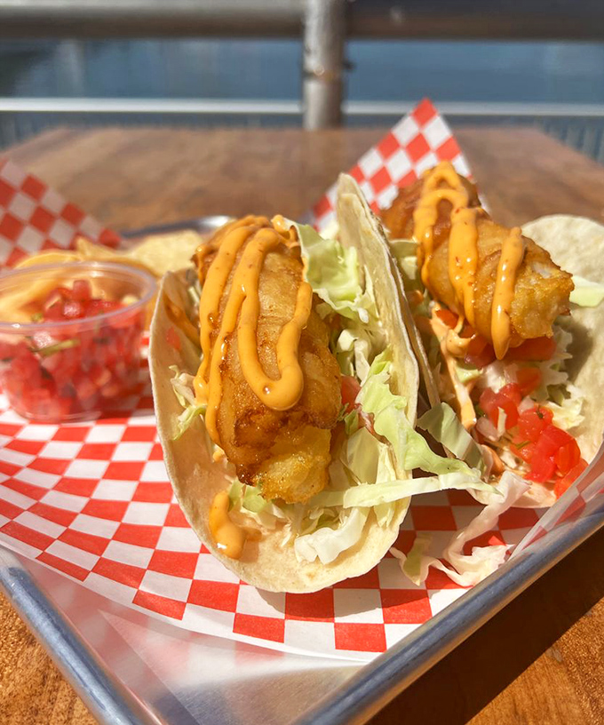Fish tacos done right: crispy battered fish, fresh vegetables, and that magical orange sauce that ties everything together like a seafood symphony.