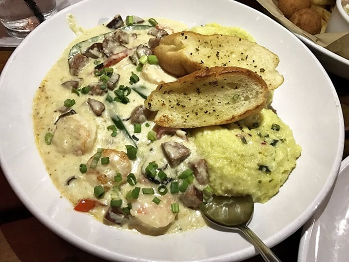 Shrimp and grits elevated to an art form&mdash;plump crustaceans swimming in creamy sauce alongside a golden island of cheesy goodness.