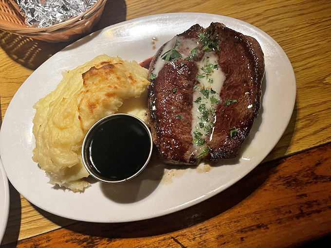 A sirloin that's been introduced to fire with proper respect, alongside a loaded potato that's dressed better than most people at the DMV.