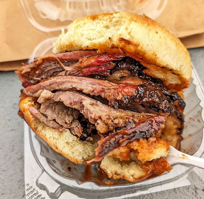 The brisket sandwich – where tender, smoke-kissed meat meets simple bread in a relationship that puts Hollywood romances to shame.
