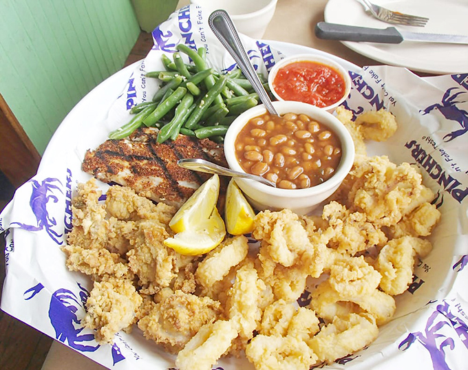 A seafood symphony on a plate&mdash;crispy calamari, blackened fish, and fried shrimp harmonizing with fresh green beans and hearty baked beans.