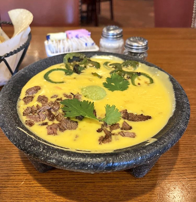 The legendary Bob Armstrong Dip &ndash; where queso meets guacamole, ground beef, and cilantro in a molcajete of pure genius.