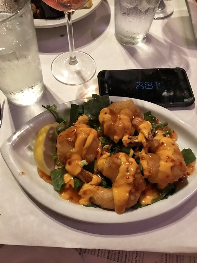 These golden shrimp, glistening with spicy sauce, aren't just appetizers&mdash;they're conversation starters that silence the table until the last bite.