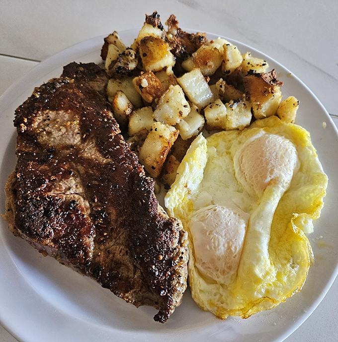 The holy trinity of breakfast: perfectly seared steak, sunny-side-up eggs, and golden home fries. Protein paradise that puts gym smoothies to shame.
