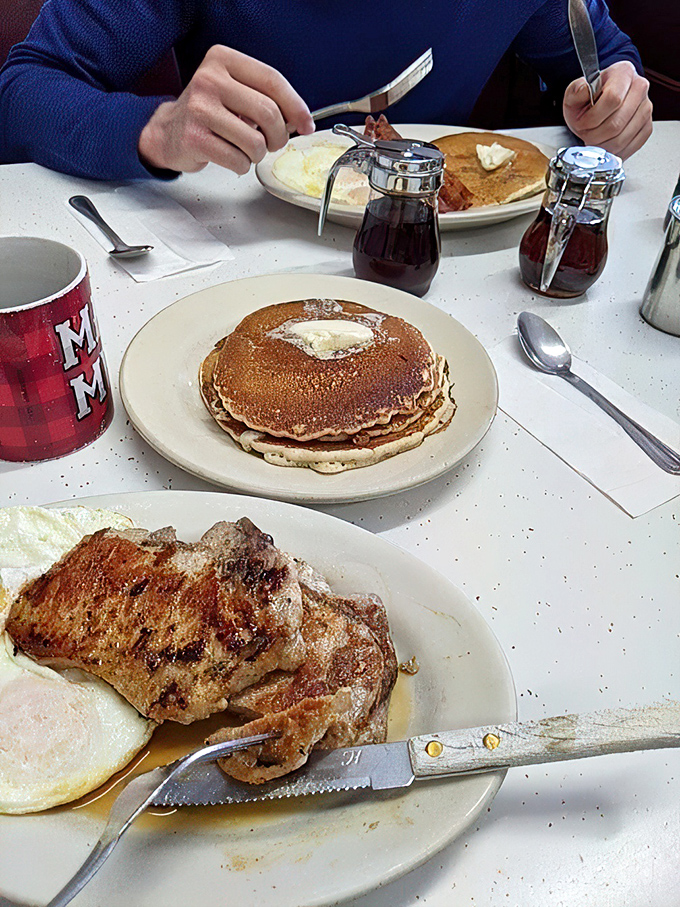 Breakfast of champions: golden pancakes with a dollop of melting butter, perfectly cooked eggs, and pork chops that would make vegetarians reconsider their life choices.