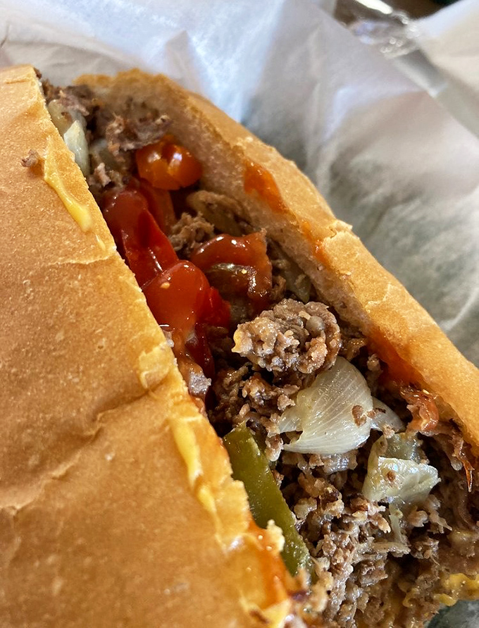 The cross-section reveals the architecture of deliciousness&mdash;layers of seasoned meat, melted cheese, and caramelized onions creating a harmony of flavors.