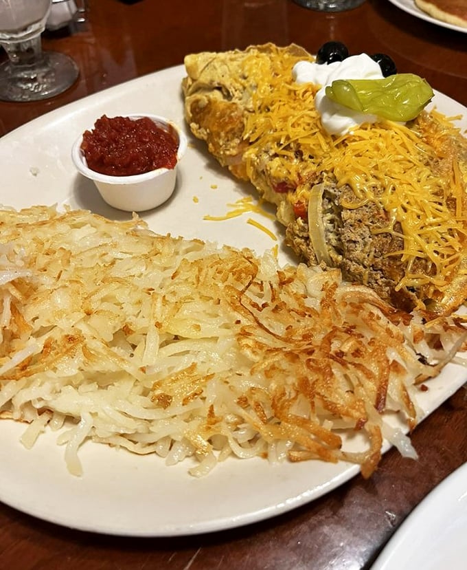 This isn't just an omelet; it's an architectural achievement. Crispy hash browns standing guard like delicious sentinels on the side.