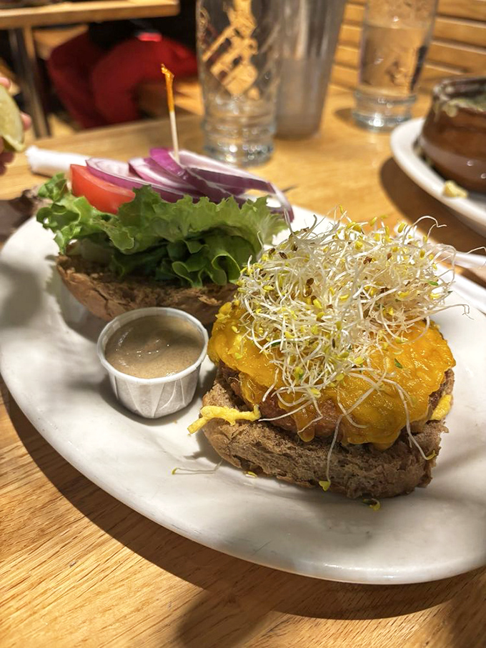 A veggie burger that could convert carnivores—topped with melted cheese, fresh sprouts, and served with a side of house-made sauce that you'll want to bottle and take home.