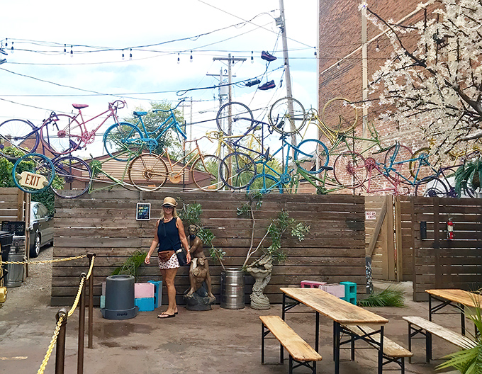 The outdoor patio adds whimsy with its bicycle collection hanging overhead, creating an unexpected oasis in the urban landscape.