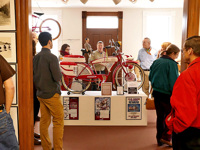 Visitors admire a striking red vintage bicycle. That's the face we all make when we realize our first Huffy wasn't quite this spectacular.