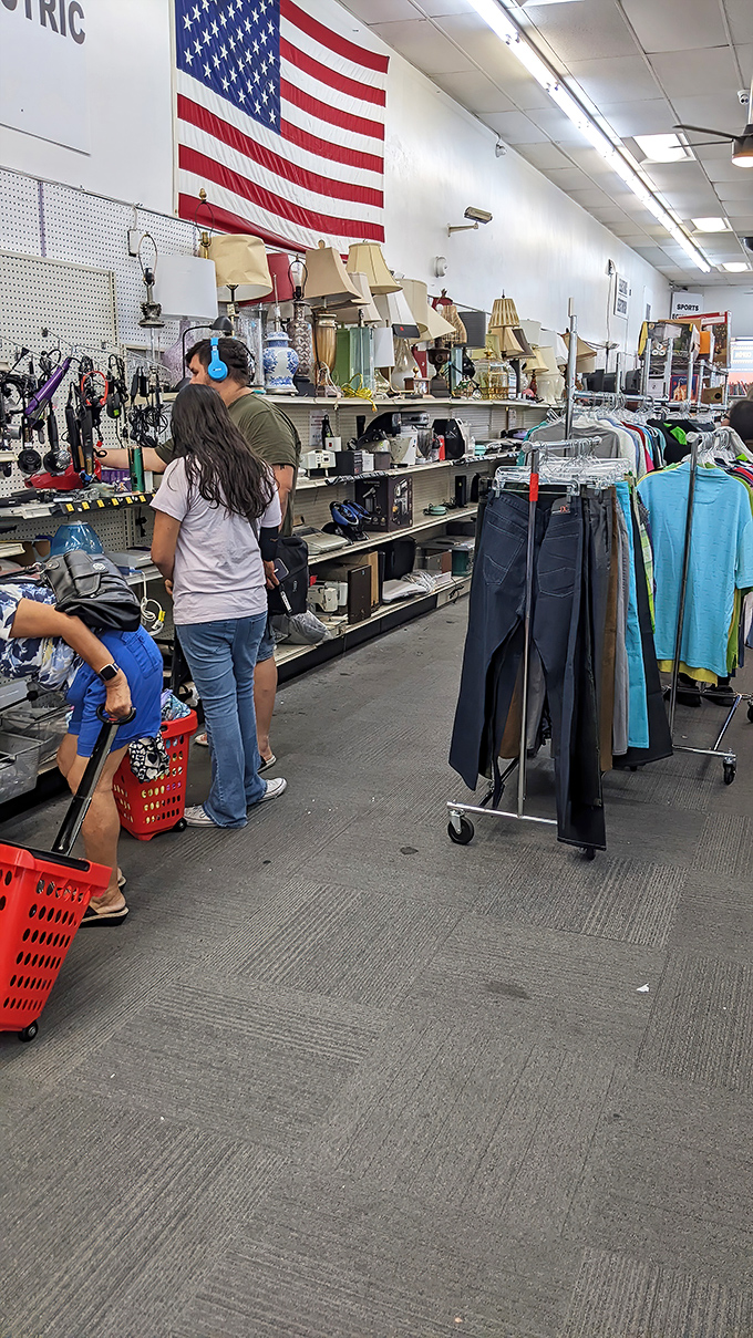 Beneath the watchful gaze of Old Glory, shoppers navigate the organized chaos like seasoned explorers on a quest for hidden gems.