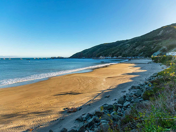Mother Nature's sandbox stretches toward gentle waves, protected by surrounding hills. No Instagram filter needed for this slice of California gold.