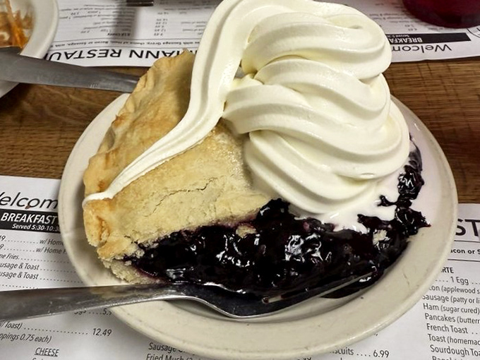 Black raspberry pie with a cloud of whipped cream so perfect it makes you wonder why anyone bothers with fancy desserts that require tweezers.