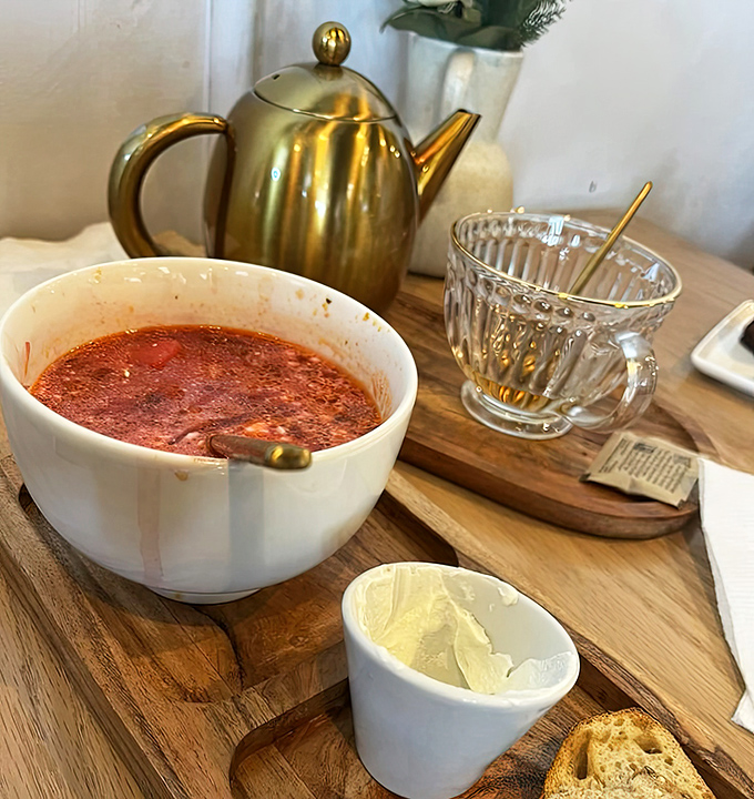 Borscht served with the respect it deserves&mdash;in proper dishware with a side of sour cream and that elegant gold teapot standing guard.