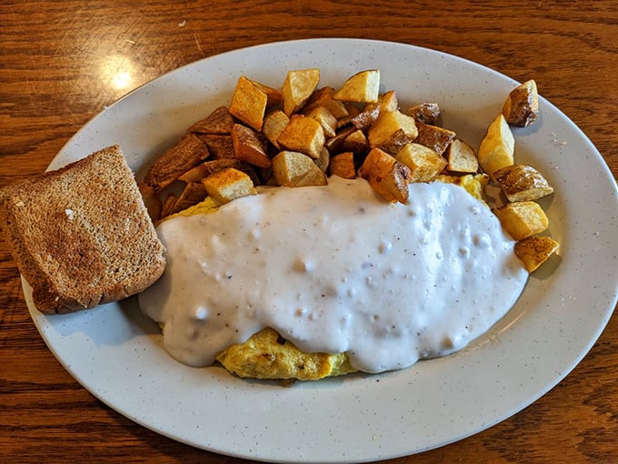 Behold the breakfast of champions: golden home fries, eggs, and gravy that would make your cardiologist wince and your taste buds applaud.