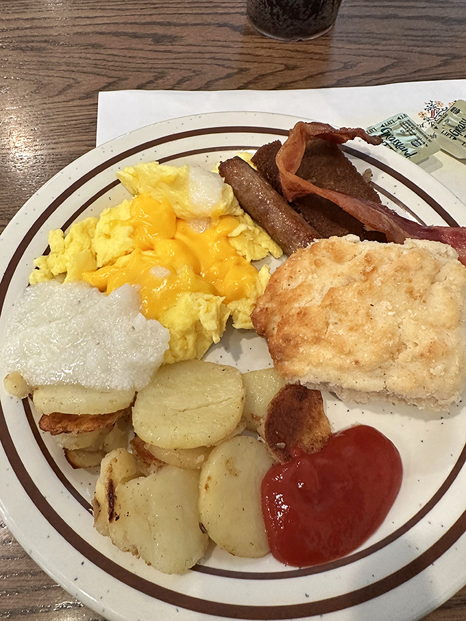 Here's what breakfast perfection looks like: fluffy eggs, crispy bacon, golden home fries, and fresh biscuit.