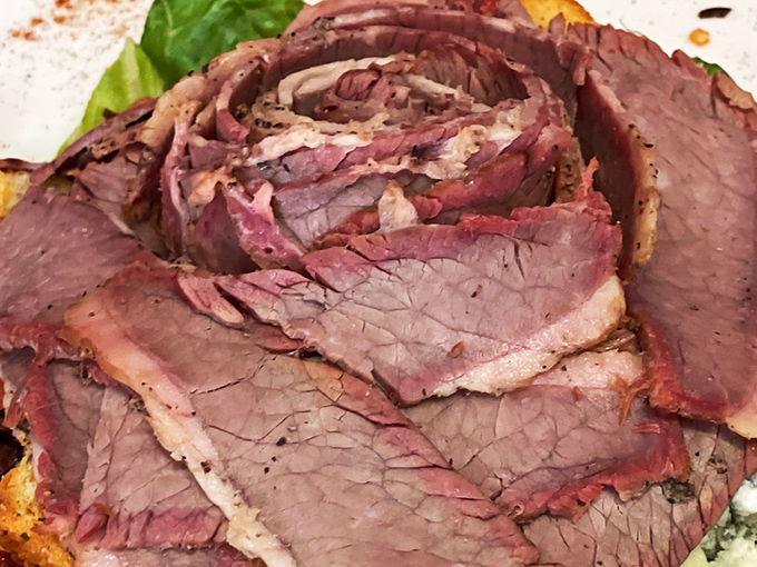 Behold the brisket's perfect pink smoke ring! This thinly-sliced masterpiece has clearly been on a low-and-slow journey to tenderness that's worth every minute.