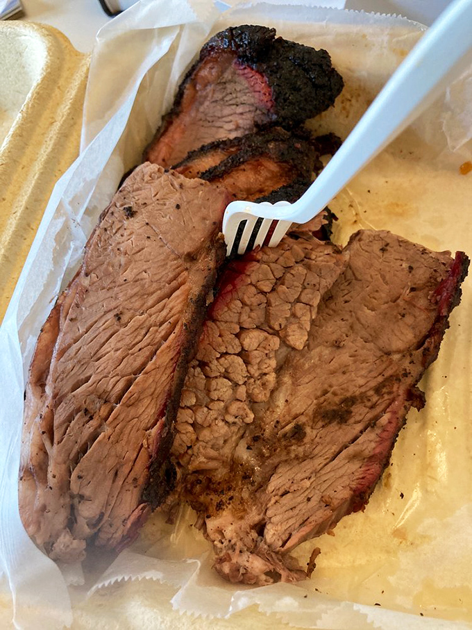 This brisket showcases the perfect smoke ring and bark that barbecue legends are made of, slice by slice.